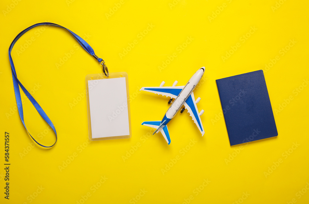 Toy air plane and passport, empty white ID card badge on yellow ...