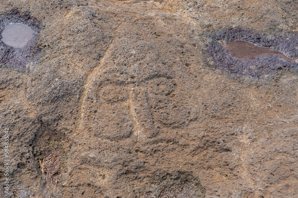 Petroglyph of face carved on the lava rock at the restored ceremonial ...