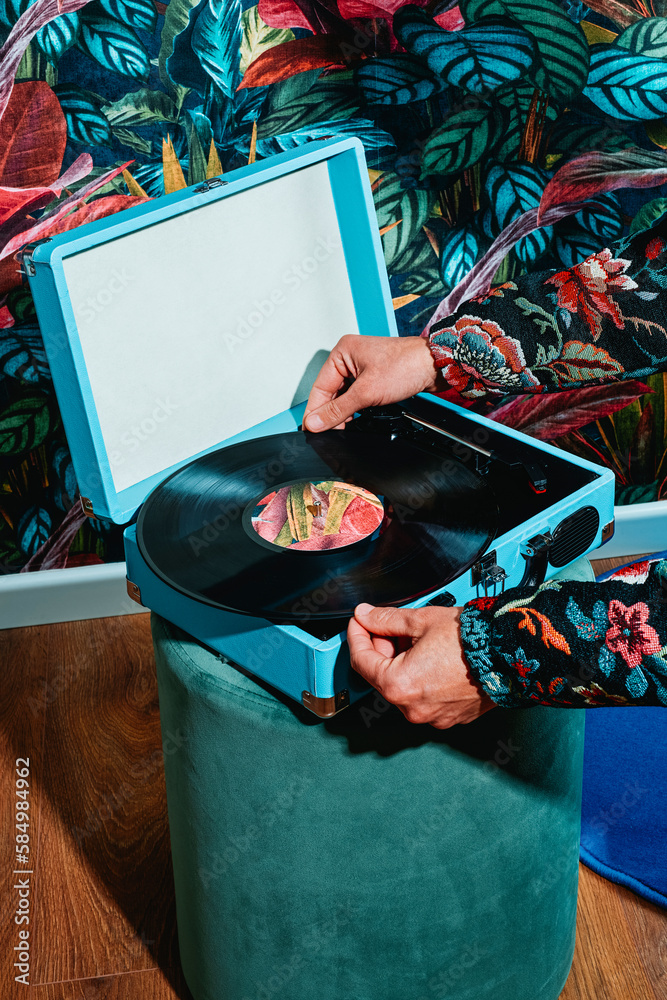 man puts a record in a retro blue turntable Stock Photo | Adobe Stock
