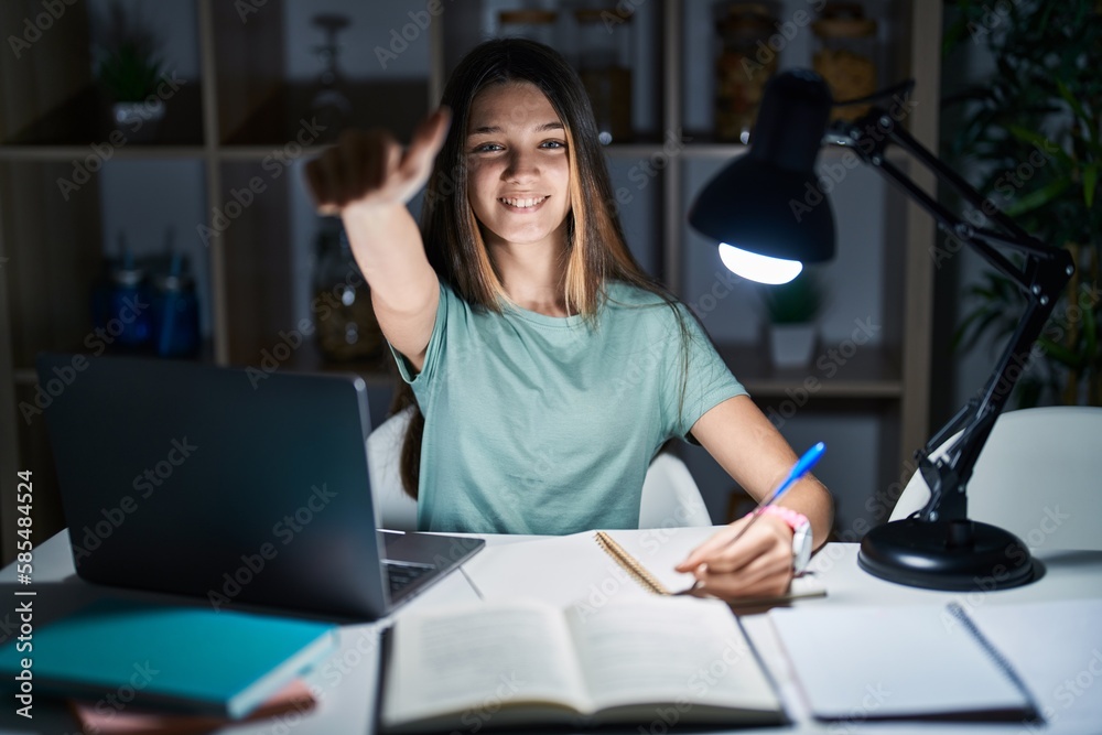 Teenager girl doing homework at home late at night approving doing ...