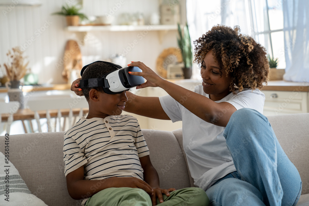 Mother limiting time child playing in virtual reality. Smiling African ...