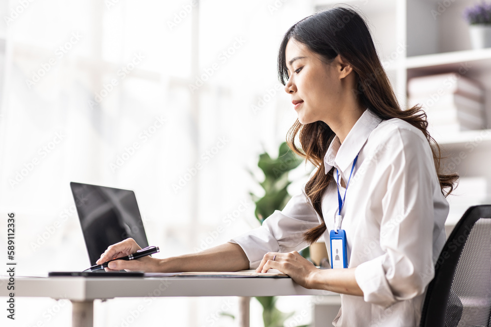 Charming Young asian businesswoman sitting on laptop computer in the ...