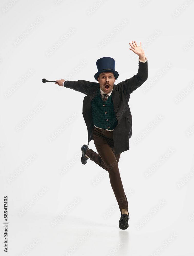 Portrait of shocked man wearing old clothes and black cylinder jumping ...