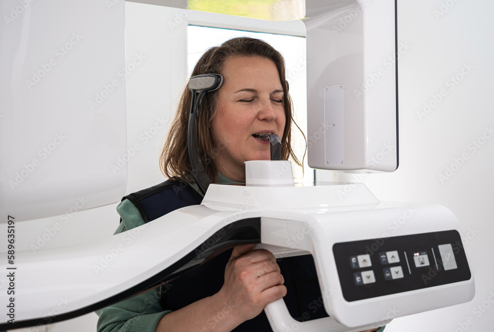 young patient undergoes an dental X-ray scan to detect any potential ...
