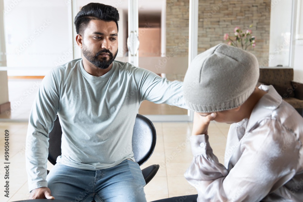 Sad and depressed south asian woman cancer patient with concealing head ...
