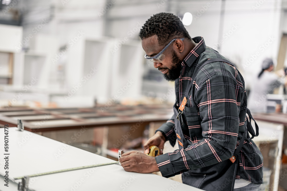 A Carpenter carefully measures, marks dimensions, and lays out ...
