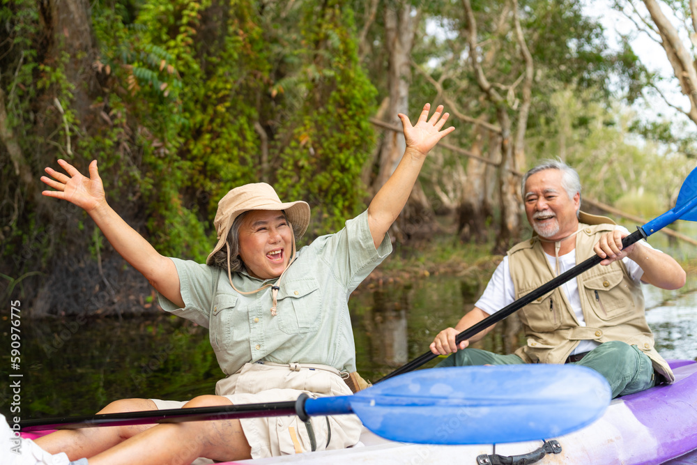 Asian senior couple kayaking together in the lake at mangrove forest on ...