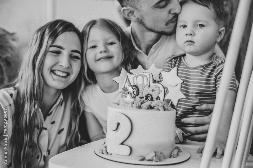 Cake. Happy family having fun celebrating birthday party 2 years old ...