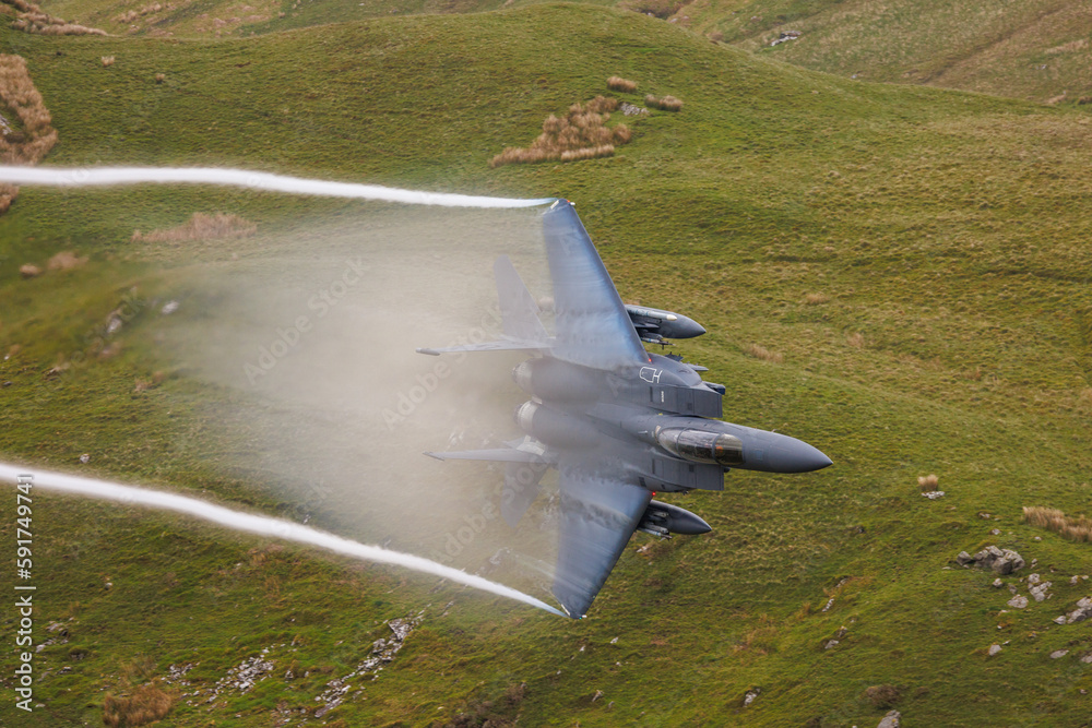 F15 fighter jet performs low flying through the mountains Stock Photo ...