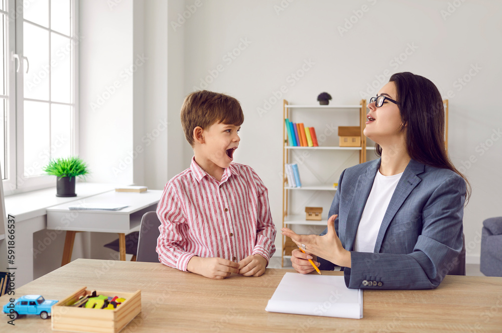 Speech therapist and boy practicing correct pronunciation in office ...