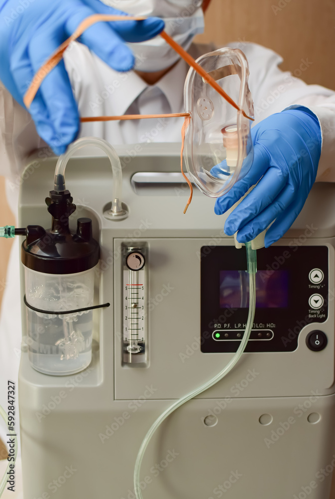 Photo Stock Hands in medical gloves hold out an oxygen mask against the ...