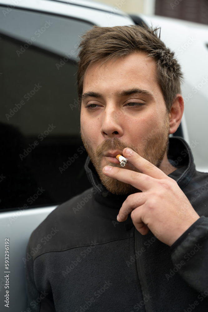 Jeune homme en train de fumer une cigarette Stock Photo | Adobe Stock