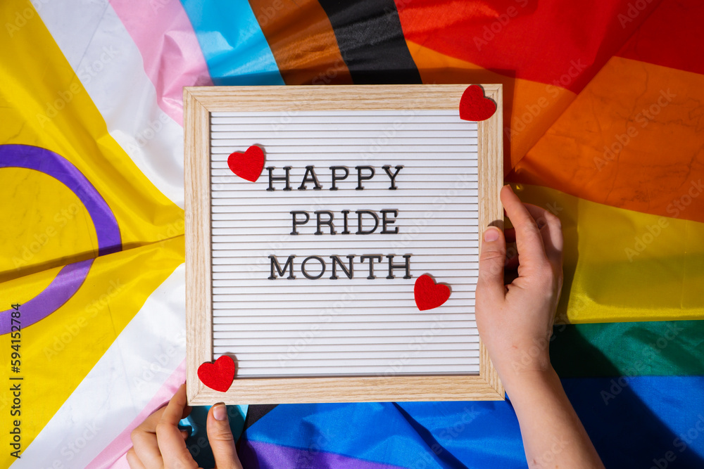 HAPPY PRIDE MONTH frame on Rainbow LGBTQIA flag made from silk material ...