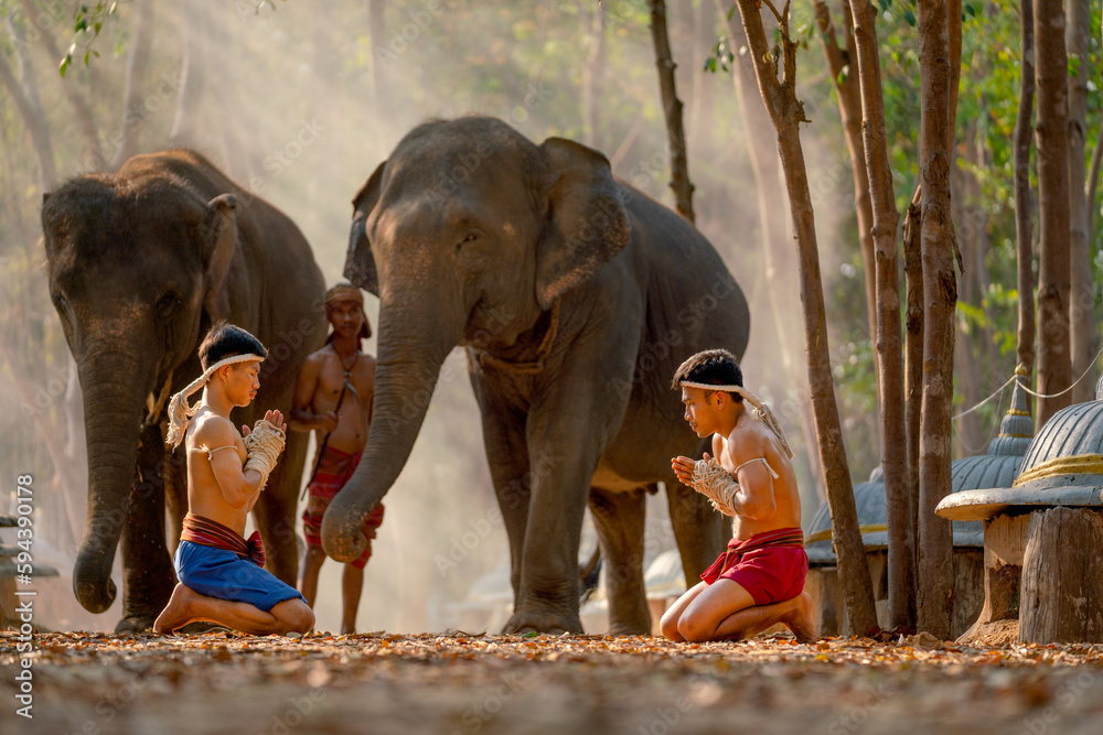 Two Asian men sit and action with traditional martial art fight by pray ...