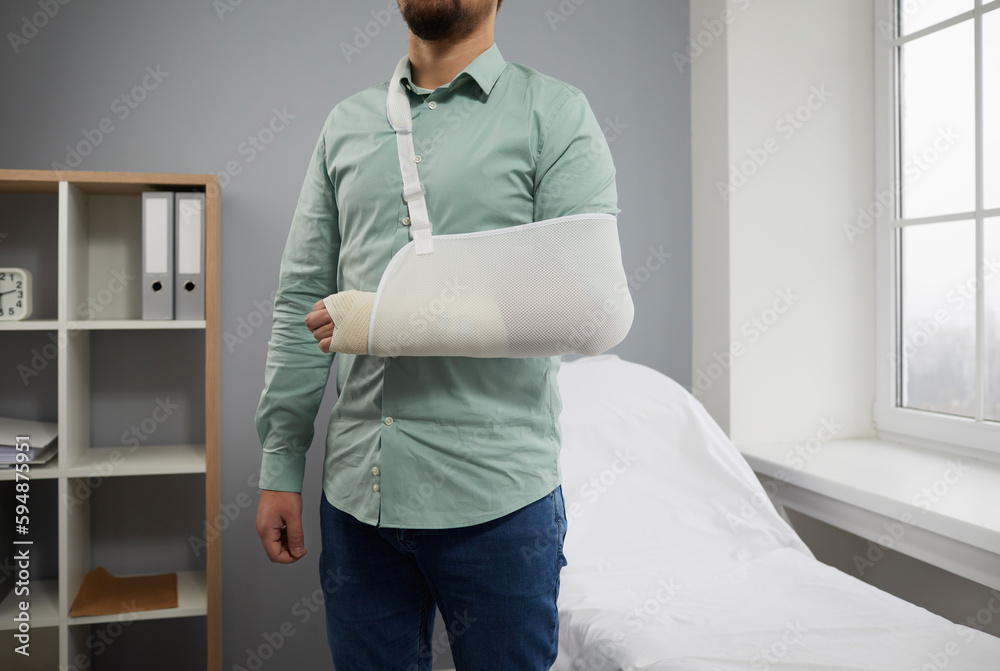Cropped shot of young man wearing white orthopedic forearm sling after ...