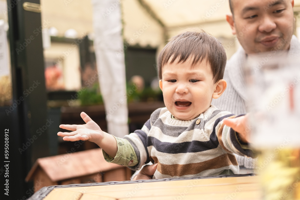 Upset male infant screaming and raising his hands with open mouth ...
