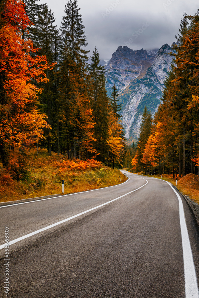Mountain road. Landscape with rocks sunny sky with clouds and beautiful asphalt road in the evening in summer. Vintage toning. Travel background. Highway in mountains. Stock Photo Adobe Stock