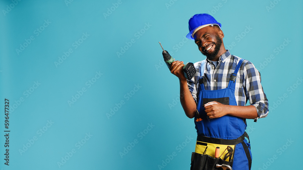 African american man using power drilling tool on wall, drill nails ...