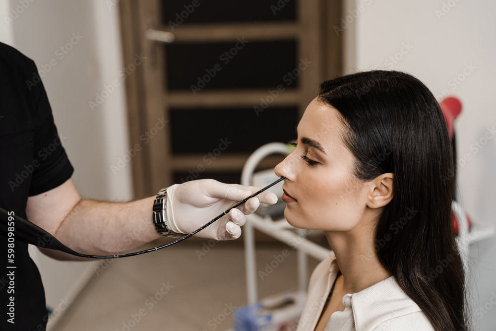 ภาพถ่าย Stock ENT doctor using fibrolaryngoscope to examine and treat ...