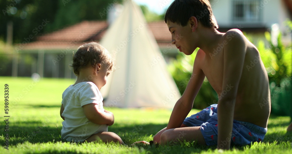 Older brother caring for baby sibling. Authentic family moment. Two ...