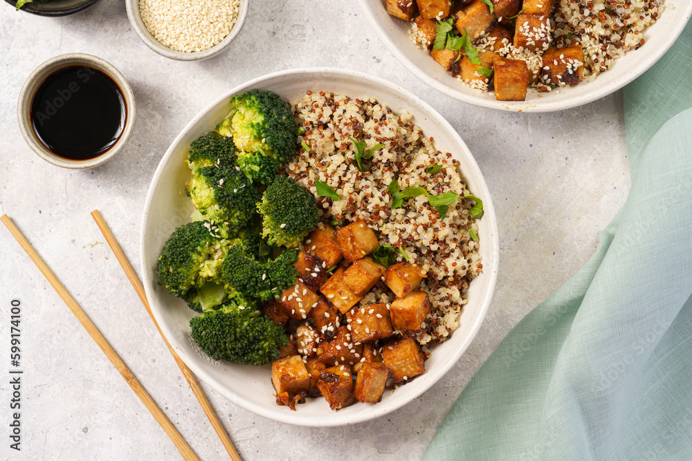 Two quinoa bowls with steamed broccoli and smoked tofu cubes in ...