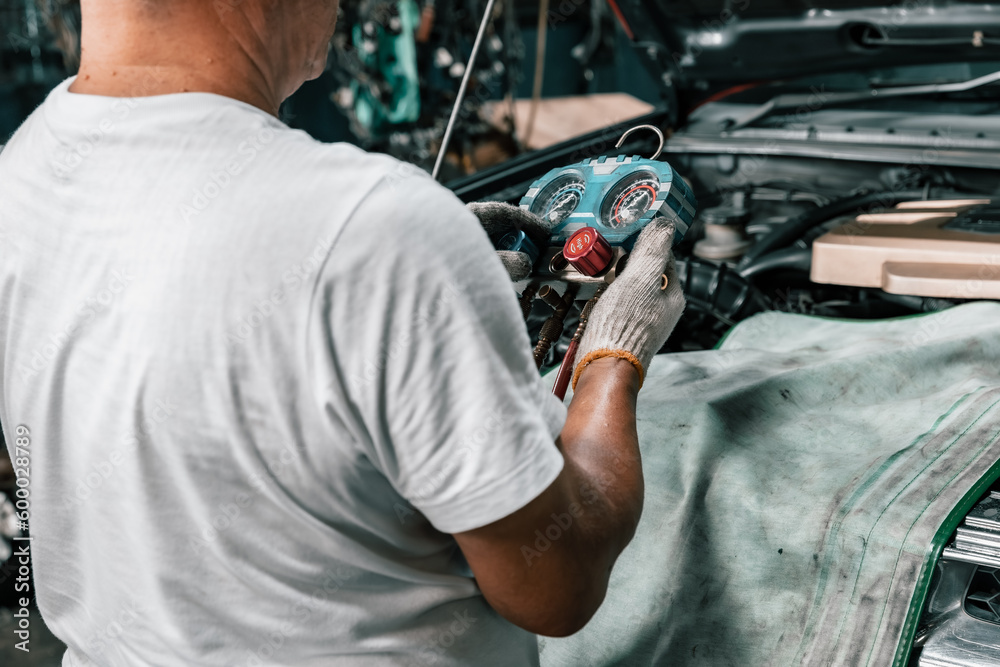 Experienced auto mechanics inspect car battery terminals and voltage to ...