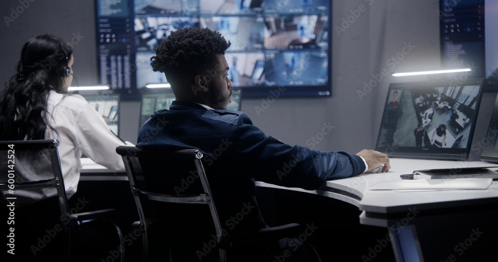 Foto de Stock Security officer sits in observation room and leans on ...