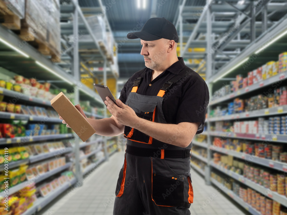 Supermarket employee. Man with box. Contractor is taking inventory ...