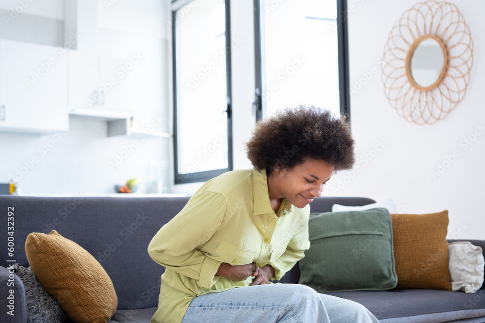 Sick young woman in pain holding belly stomach feeling hurt abdomen ...