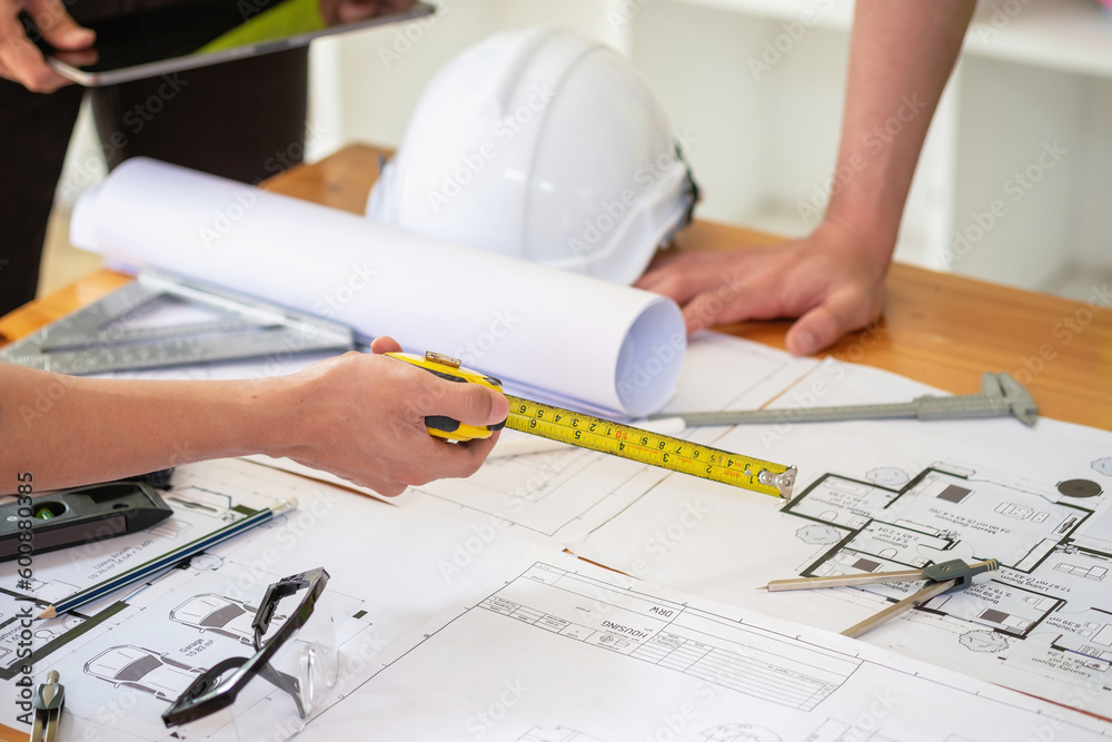 Asian engineers brainstorm and measure to document cost estimates and ...