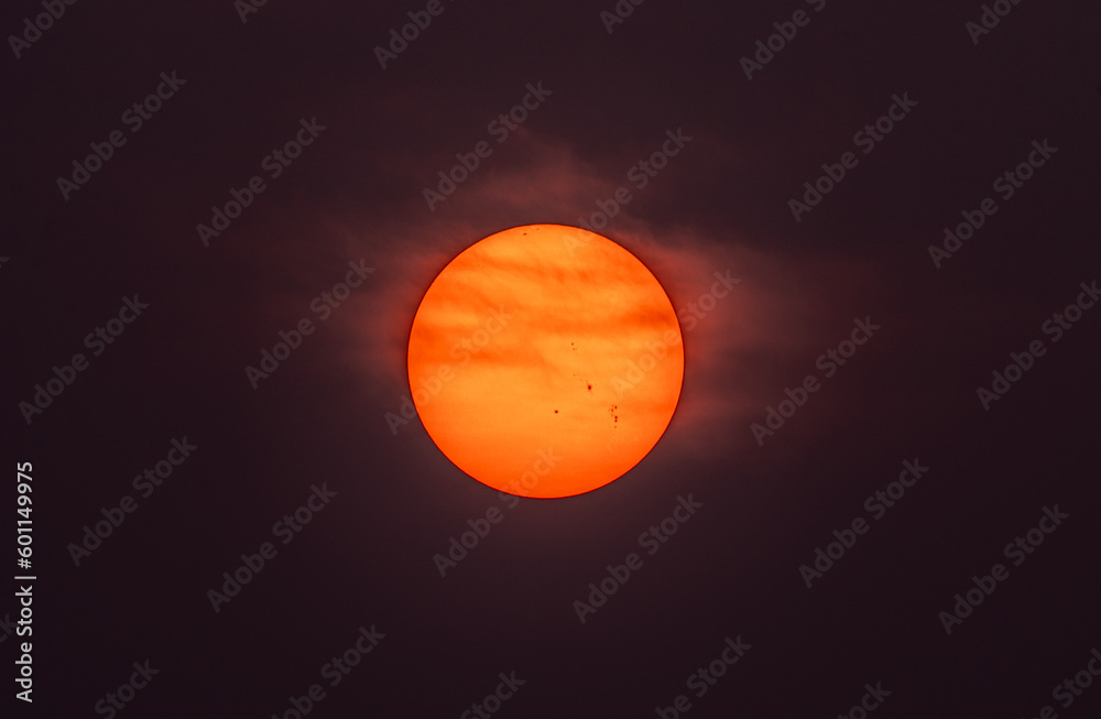 Photo Stock Hazy celestial red sun with sunspots on the surface ...