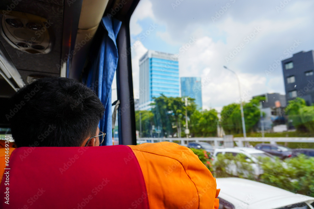 Looking out the window of a moving bus, a man is captivated by the ...