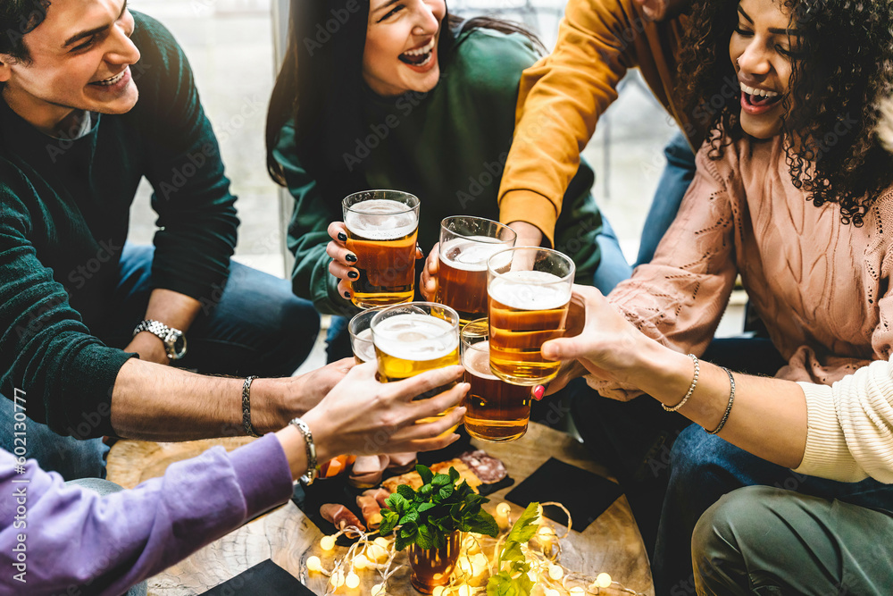Group of multiracial friends drinking and toast beer at brewery pub ...