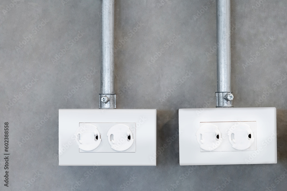 White safety outlet plug cover on the wall. Child electrical power ...