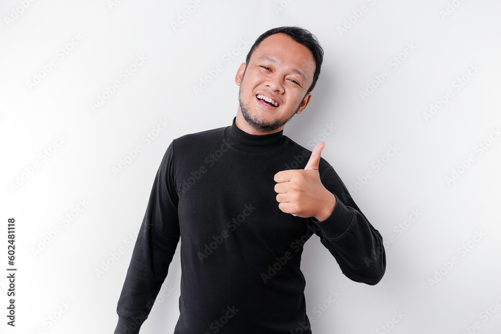 Excited Asian man wearing black shirt gives thumbs up hand gesture of ...