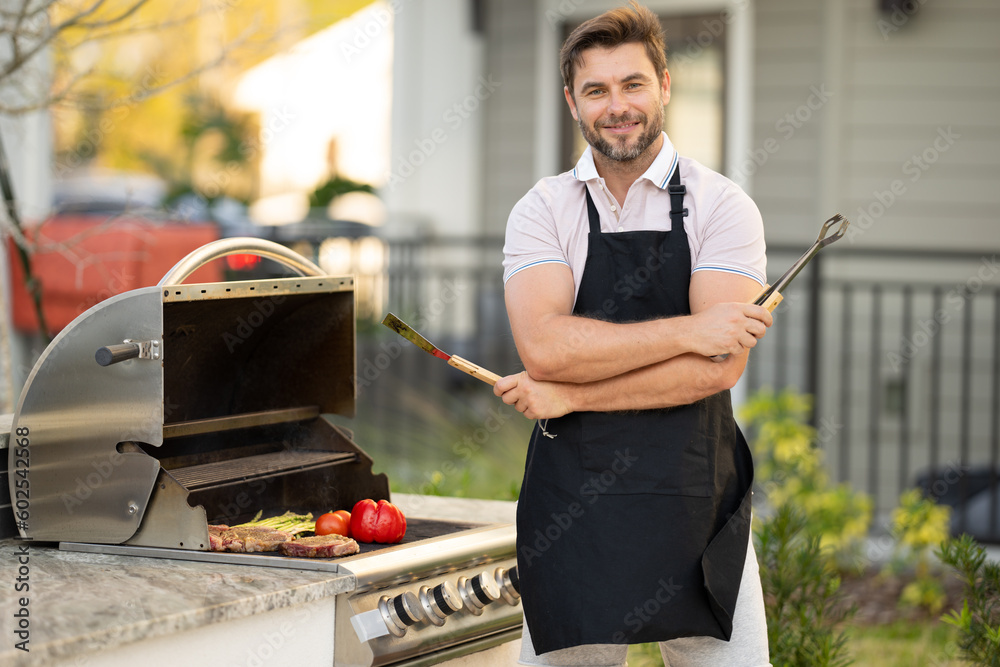 Male chef grilling and barbequing in garden. Barbecue outdoor garden ...