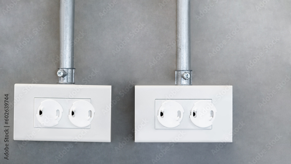 White safety outlet plug cover on the wall. Child electrical power ...