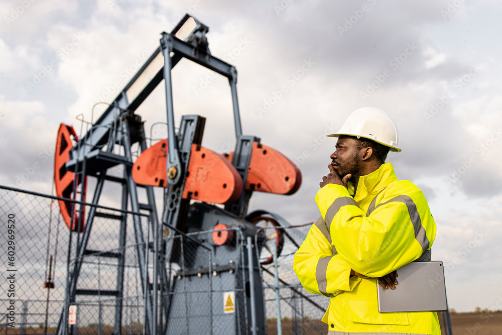 Oil field operator standing by the oil rig and controlling crude oil ...