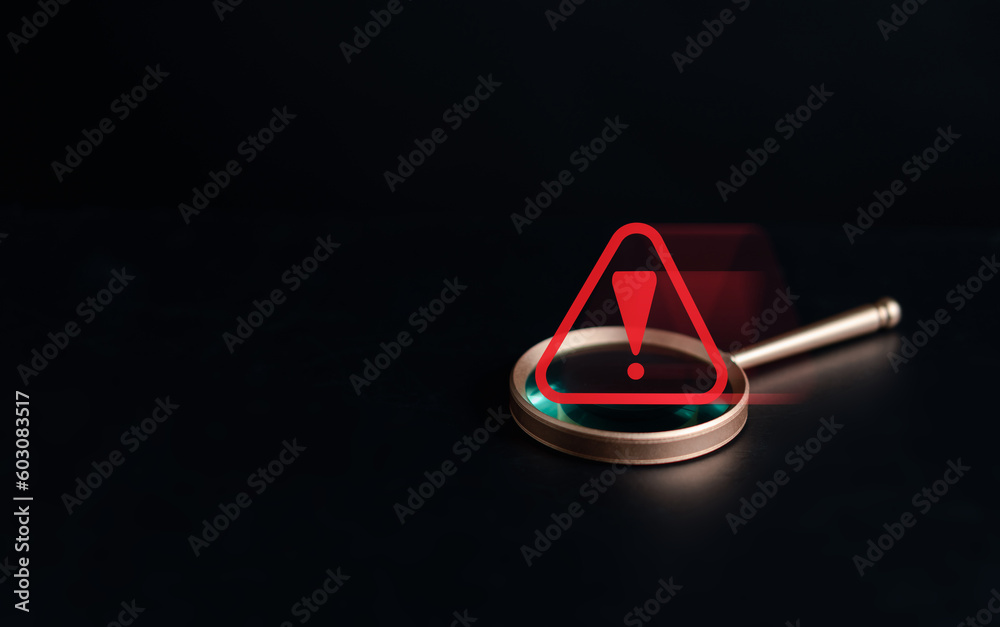 System warning caution sign inside magnifier for notification error and ...