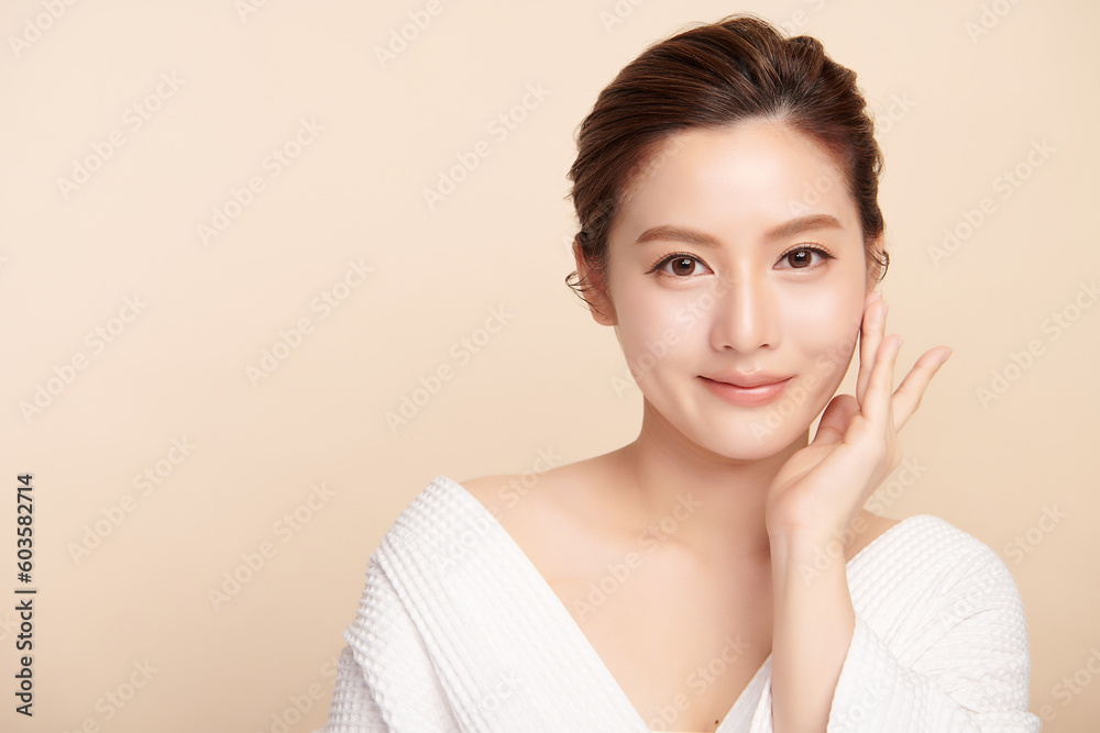 Beautiful young asian woman with clean fresh skin on beige background ...