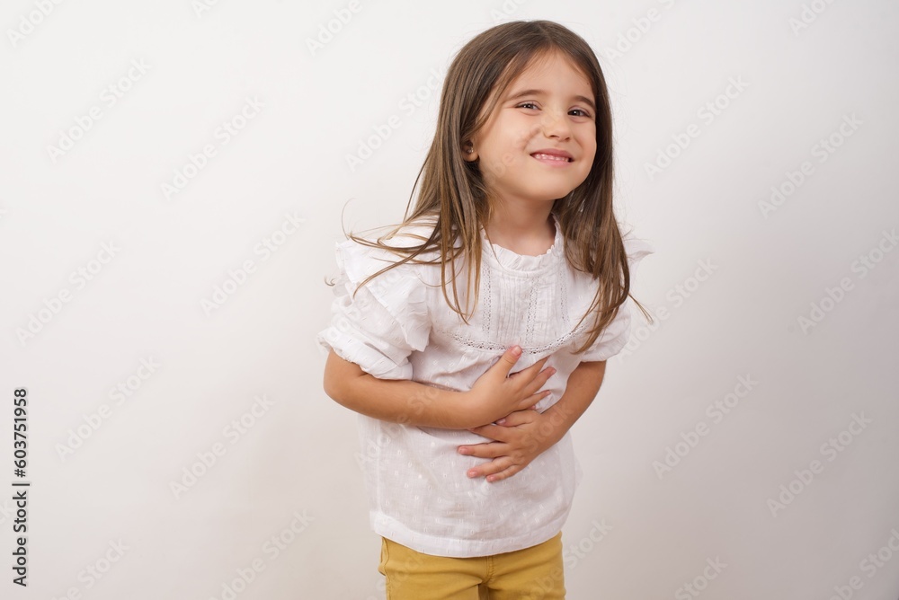 Cute charming little girl wearing white shirt over white studio ...