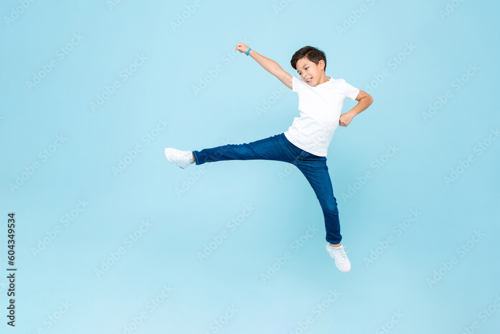 Cute mixed race Asian kid boy playing by jumping with wide open legs ...