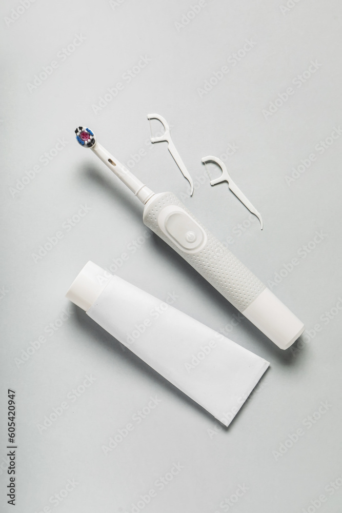 Electric toothbrush with paste and toothpicks on grey background Stock ...