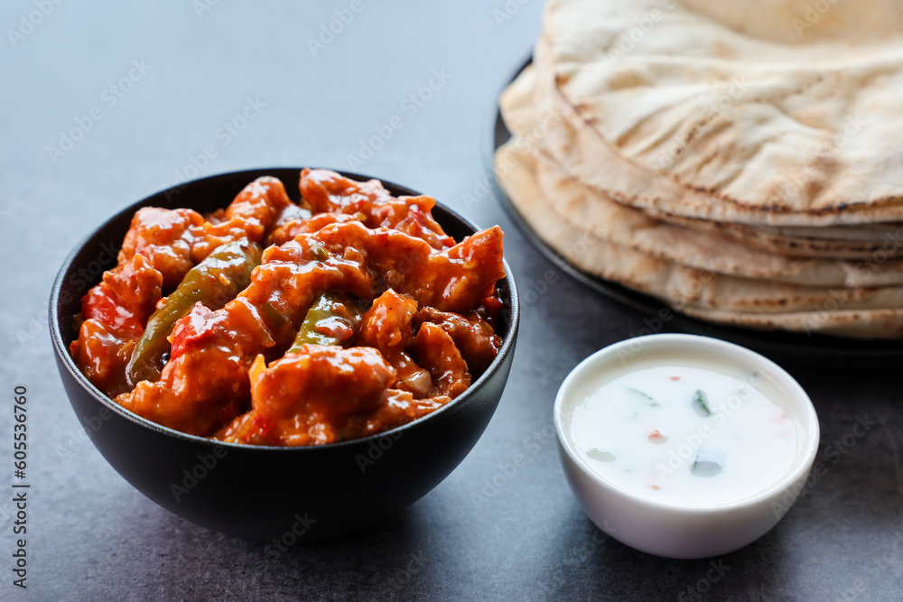 Schezwan Chicken or Dragon Chicken in black bowl at dark slate ...