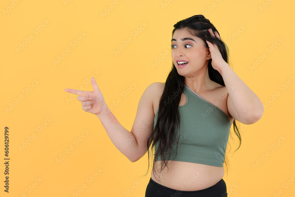 Fotografie Finger Pointing to the Left by Happy Young Indian Girl Face ...