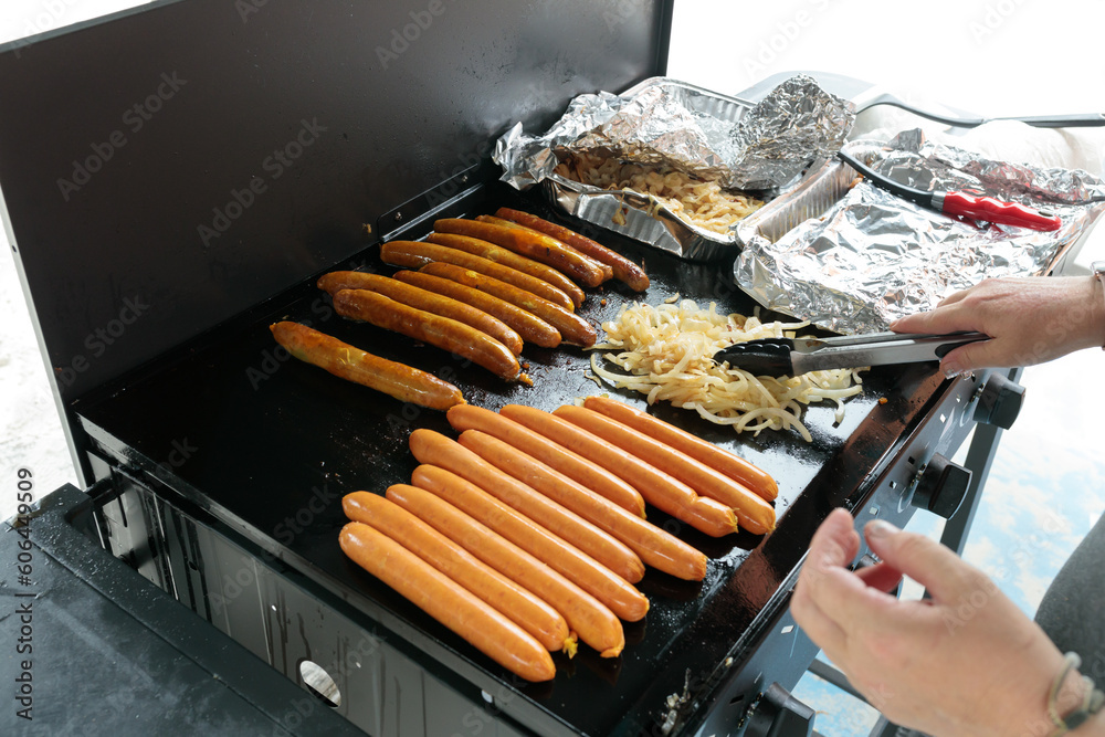 An unrecognisable person cooking a traditional australian bbq sausage ...