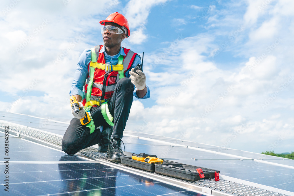 African American engineer maintaining solar cell panels on factory ...