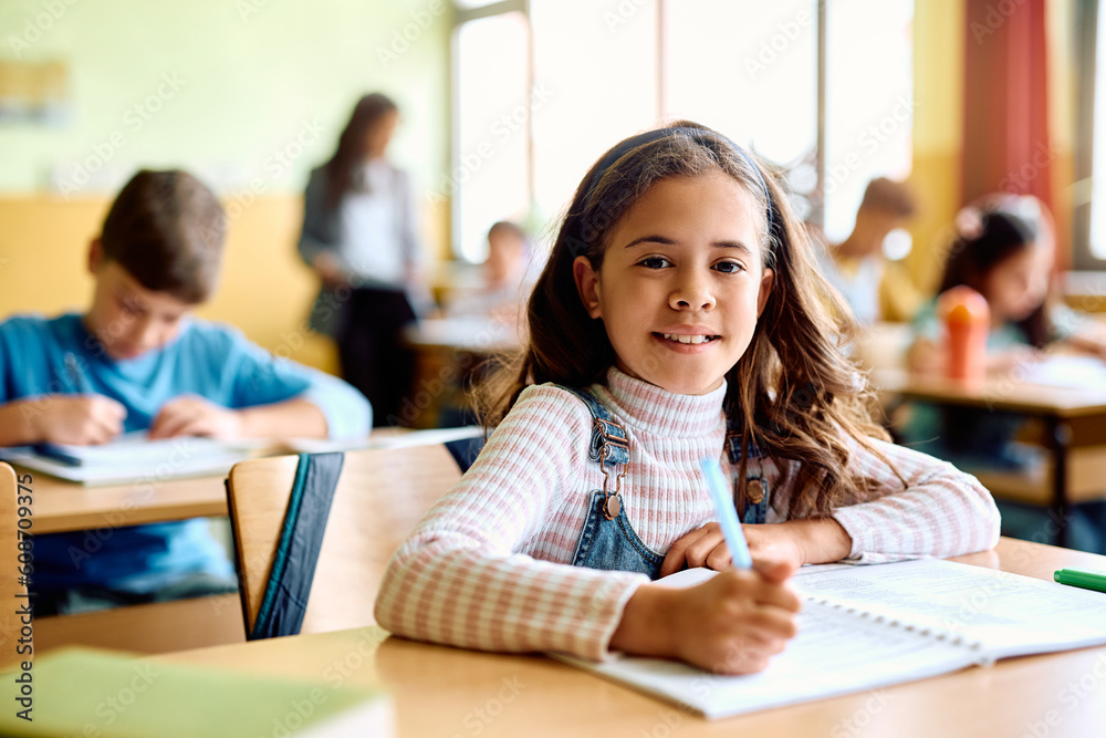 Happy Hispanic girl learning during class at elementary school and ...