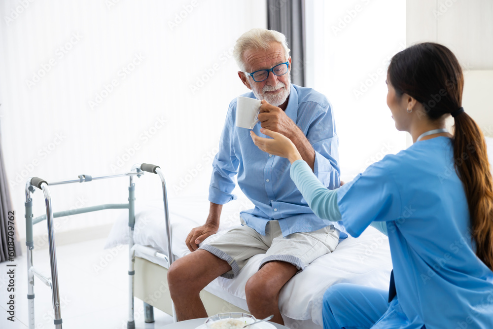 Geriatric nurse asian female talking with senior man patient drinking ...