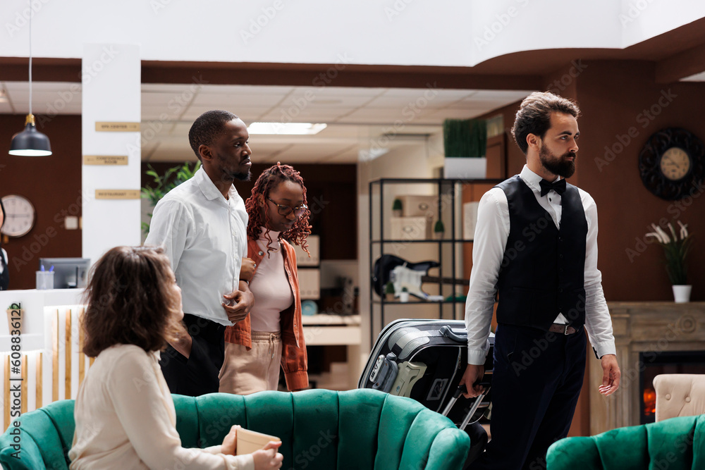 Bellboy taking care of guests luggage, carrying suitcases to room after ...